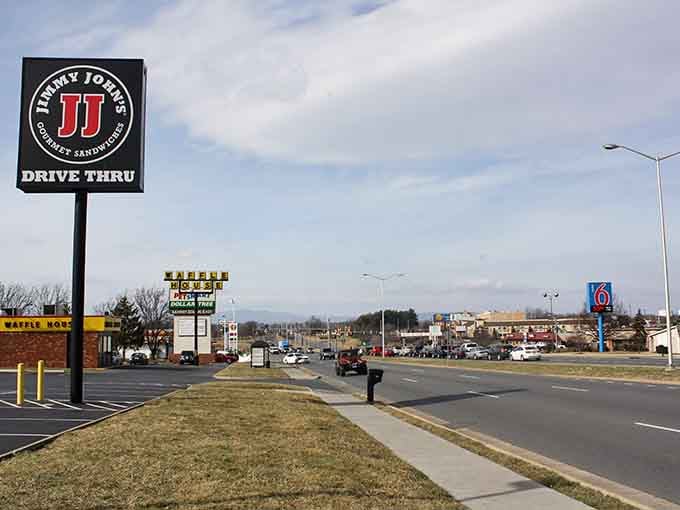 Harrisonburg offers convenient shopping and dining options along its main roads, with mountains visible in the distance on clear days.