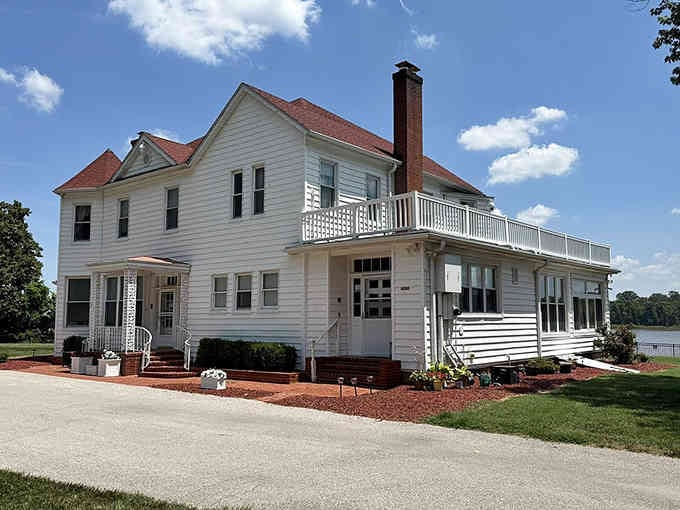 This pristine white riverside home with its wraparound porch practically begs you to sit and watch the water.