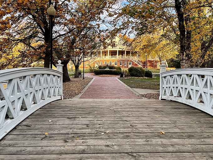 That white wooden bridge frames the pavilion in autumn gold, creating a scene so romantic it belongs on a greeting card.