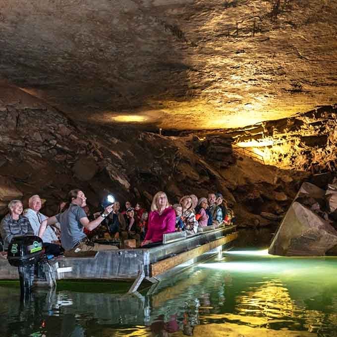 Visitors gather on floating platforms beneath golden stone, experiencing geology's greatest hits from the best seats available.