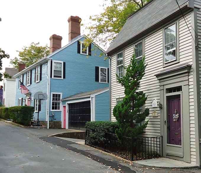 Colonial homes stand shoulder to shoulder, their colorful facades creating a rainbow of New England architectural history on display.