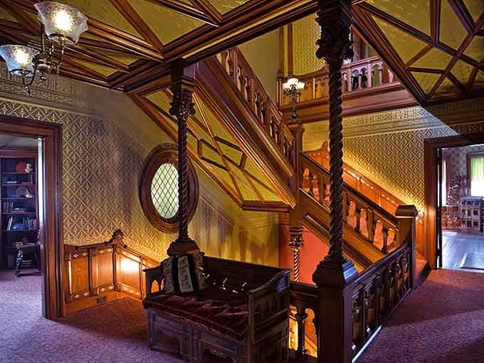 The ornate carved staircase and rich wood paneling inside reveal the craftsmanship and elegance of America's Gilded Age splendor.