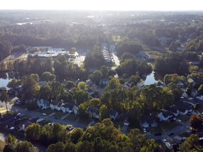 Morning light bathes tree-covered neighborhoods where front porches still serve as the original social media platform.