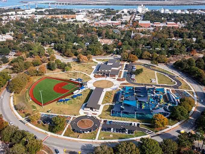 This aerial view reveals a community built around recreation, where sports fields meet splash pads in perfect harmony.