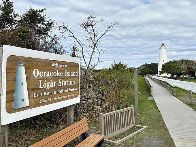 The welcoming wooden sign and boardwalk create a perfect invitation to explore this charming island lighthouse sanctuary.