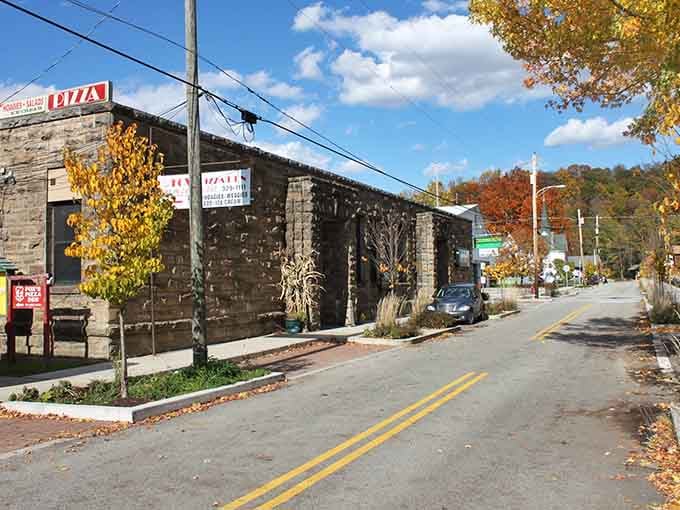 That stone building has seen generations pass by, standing solid while golden leaves dance down the quiet street.