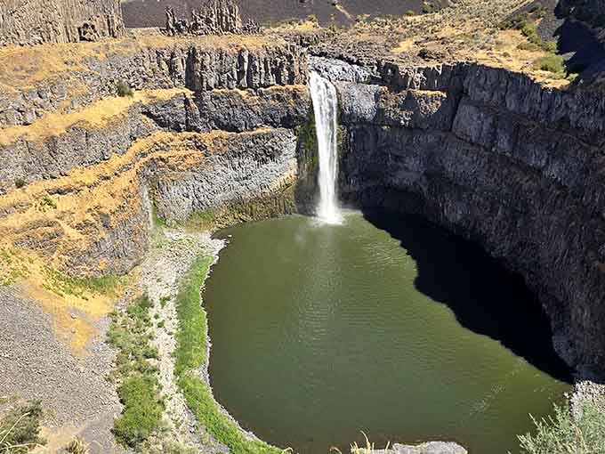 Layered canyon walls frame the waterfall's descent, each stripe telling stories from millions of years past.