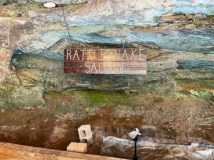 The rustic wooden sign and stone overhang promise an unforgettable meal in nature's own dining room.