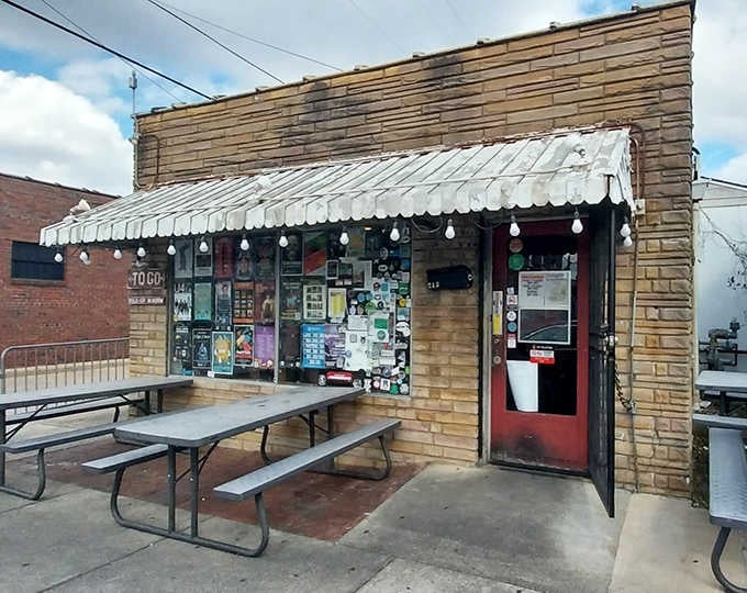 The weathered exterior and string lights create an inviting atmosphere where barbecue smoke and good times mix perfectly together.