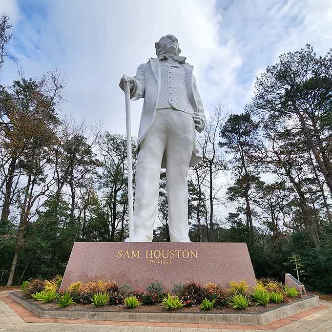 Surrounded by towering pines, this white statue commands respect while the landscaped base adds welcoming color and charm.