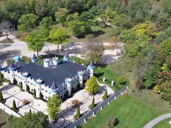 From above, the castle's battlements and pointed towers create a fairy-tale fortress surrounded by manicured green lawns.