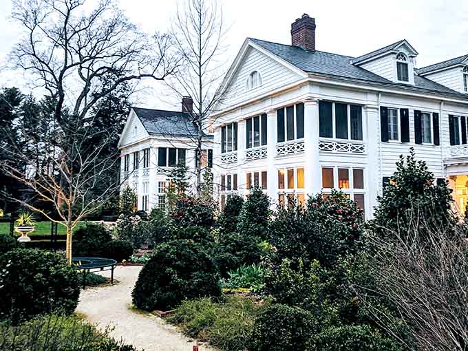 As dusk settles over the manicured grounds, warm lights glow from windows that may hide more than memories.