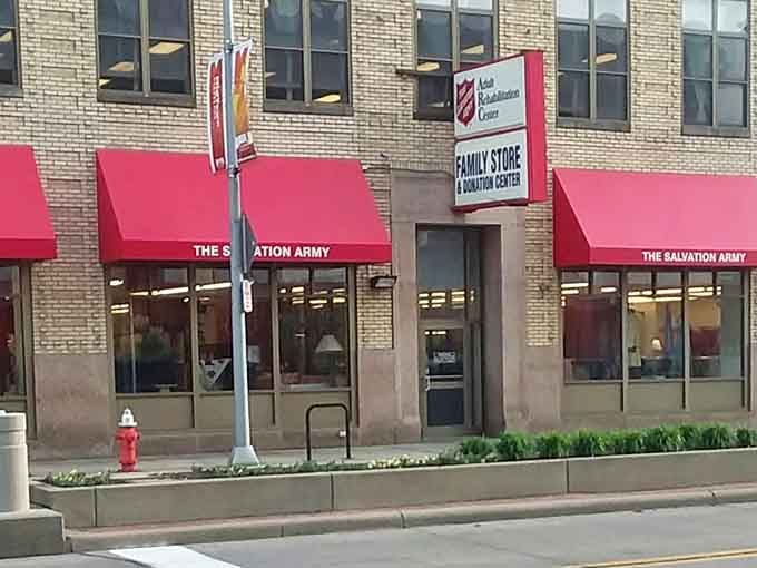 Red awnings pop against cream brick, creating a welcoming storefront that's hard to miss.