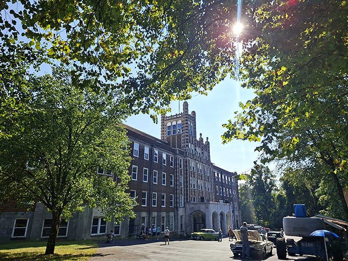 Sunlight filters through the trees, casting dramatic shadows on this imposing building that's seen countless stories unfold.