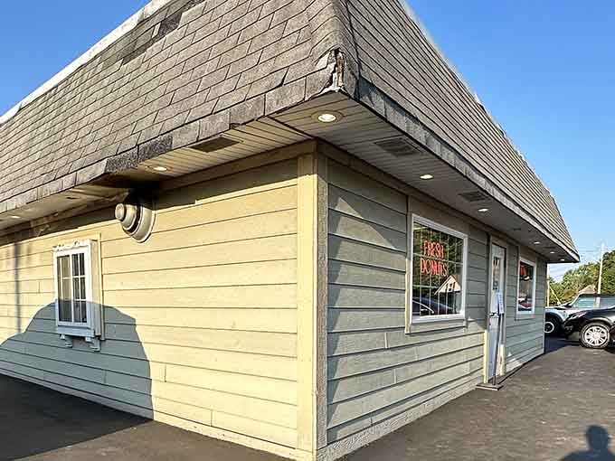 Cheerful yellow and gray siding wrap this cozy corner bakery, where the "Fresh Donuts" sign glows like a lighthouse for breakfast.