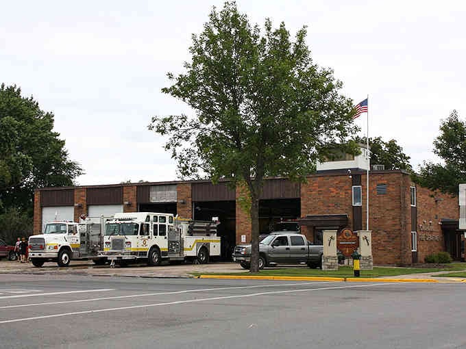 The fire station stands ready with its bay doors open, showing small-town heroes who know everyone by name.