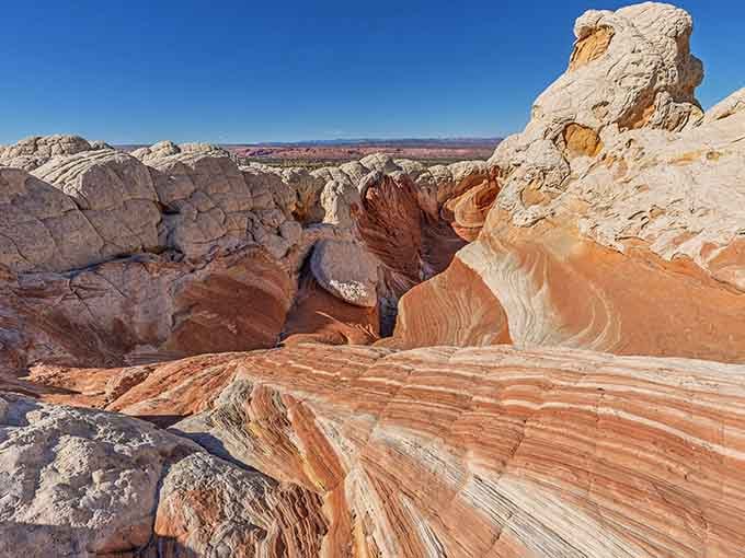 Layers of cream, coral, and crimson sandstone fold together like marble cake batter that turned to stone mid-swirl.