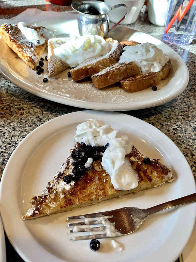 French toast topped with whipped cream and berries turns breakfast into dessert without anyone judging your choices.