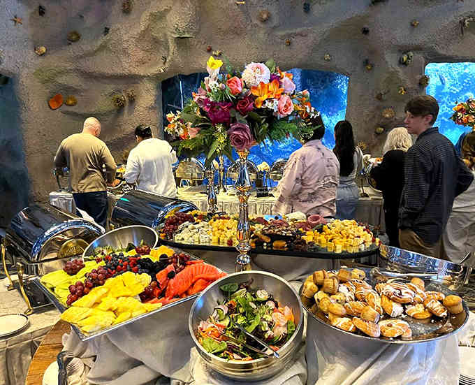 The buffet spread looks like a celebration waiting to happen, complete with fresh fruit and elegant floral arrangements.