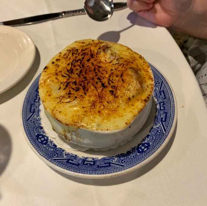 Three cheese onion soup arrives bubbling hot with a golden crust that demands your immediate attention.