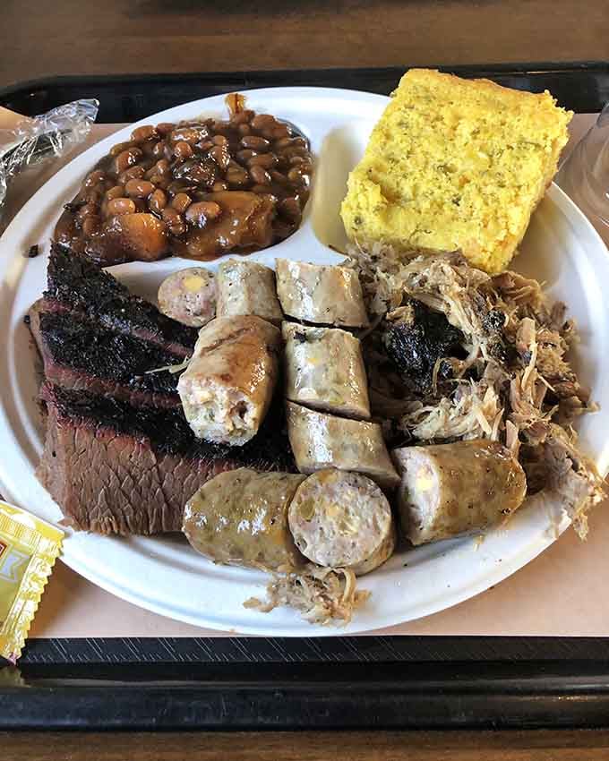 Three meats, two sides, and enough cornbread to make your cardiologist schedule an intervention meeting immediately.