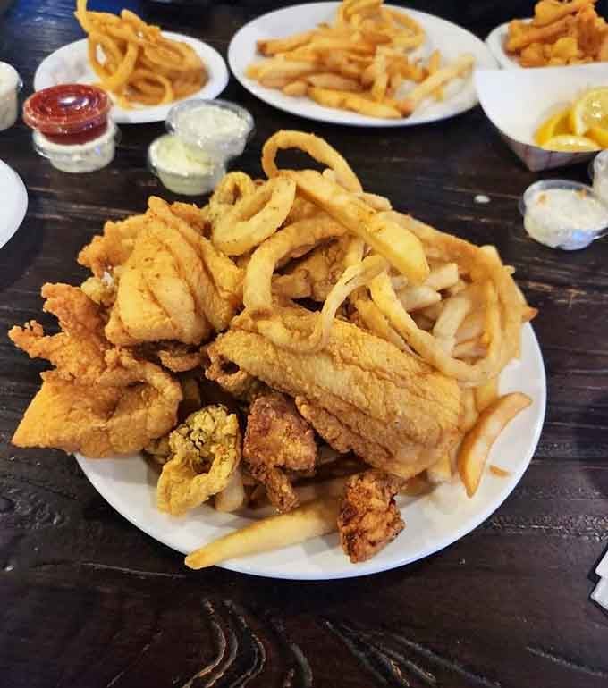 A seafood platter loaded with fried favorites and onion rings, because variety is the spice of life by the harbor.