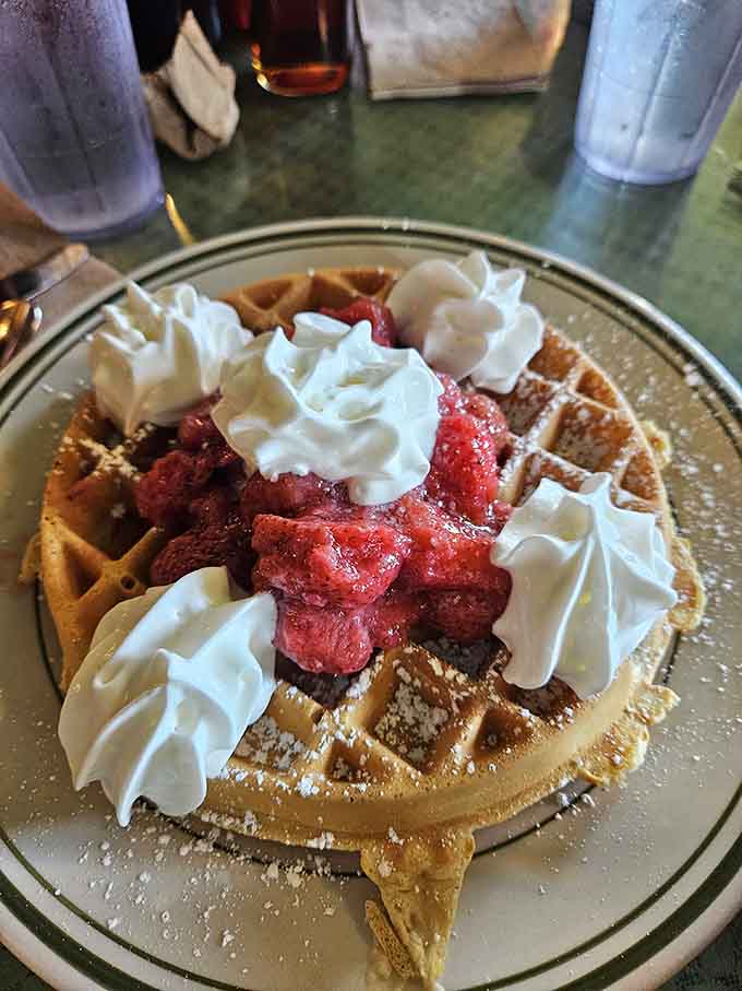 Fresh strawberries and whipped cream crown this waffle like it just won breakfast royalty, which it absolutely has.