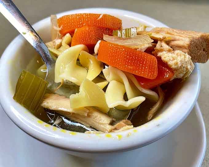 Chicken noodle soup with actual chunks of tender meat and vegetables swimming in golden, soul-warming broth.