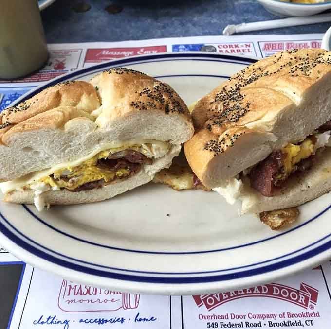 A breakfast sandwich on a fresh roll that understands the assignment and delivers with enthusiasm and melted cheese.