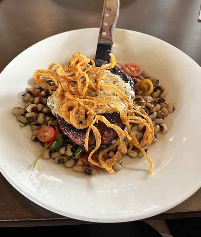 BBQ pork ribeye with crispy onions sitting on black-eyed peas is the kind of plate that makes conversation temporarily impossible.