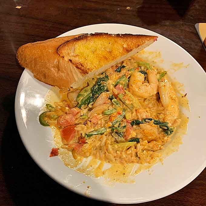Shrimp swimming in creamy sauce with garlic bread standing by like the world's most delicious life preserver.