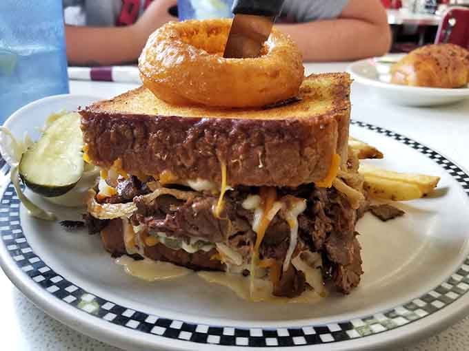 This sandwich doesn't just push boundaries; it demolishes them with an onion ring crown of glory.