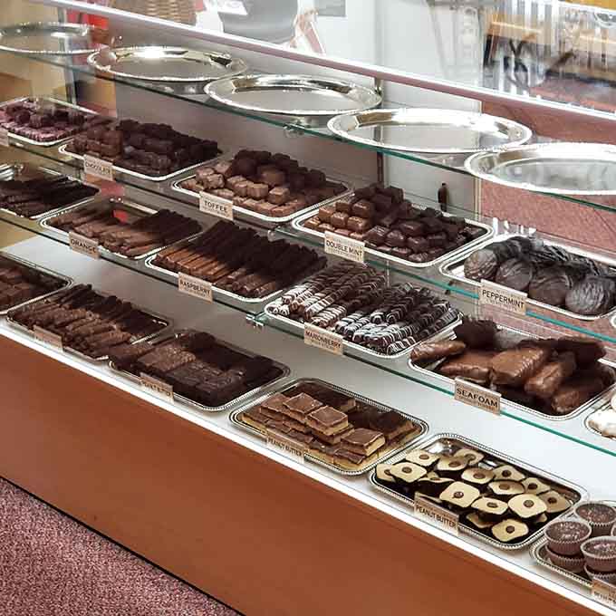 The chocolate display case showcases more varieties than you knew existed, each one begging for your attention.