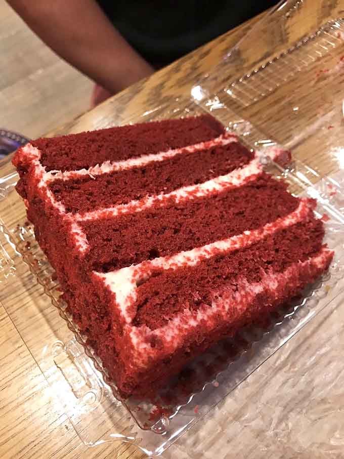 Red velvet cake sliced thick and proud, its cream cheese frosting creating layers of pure Southern-meets-Jersey magic on every plate.