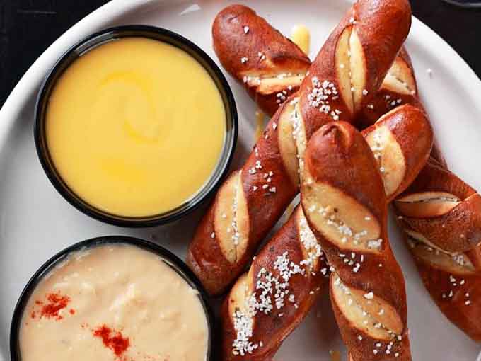Giant salted pretzel sticks with dipping sauces, proving that some childhood favorites only get better with age.