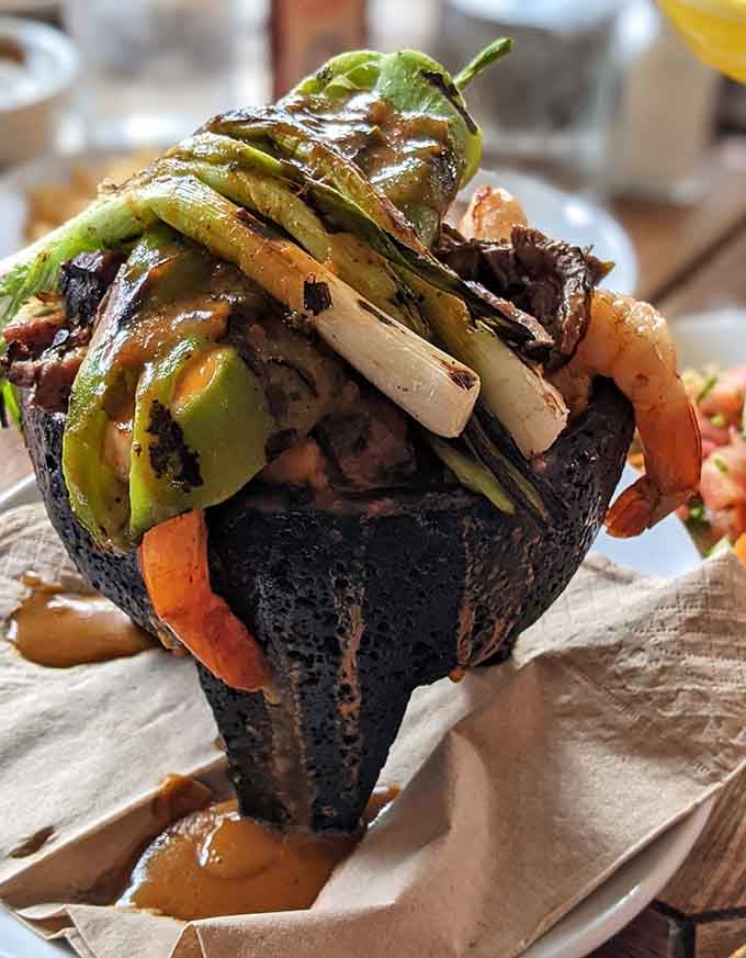 The molcajete arrives sizzling like a volcanic rock concert, and your taste buds just scored front row seats.