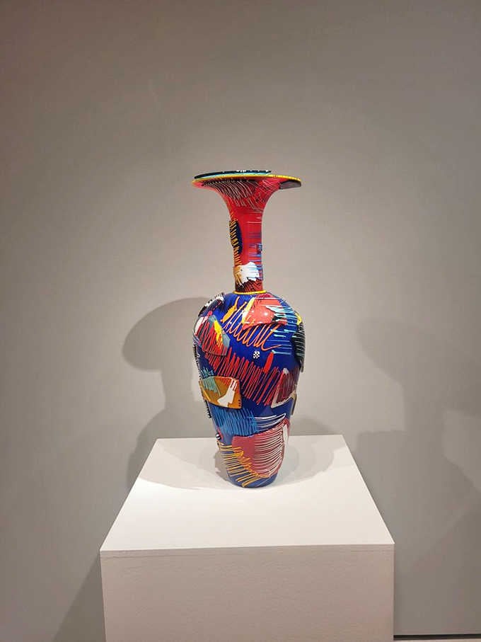 Hand-blown glass becomes a vibrant vase, its colorful patterns swirling like a kaleidoscope frozen in time.
