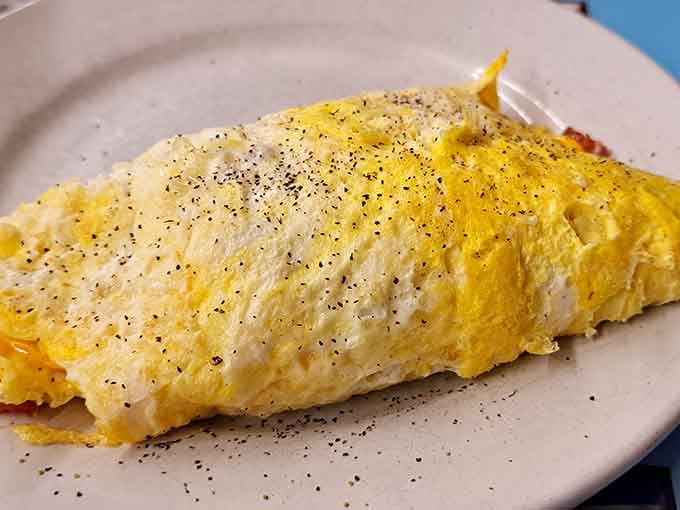 That omelet is folded with the precision of origami, fluffy as a cloud, and generously stuffed with all the good stuff.