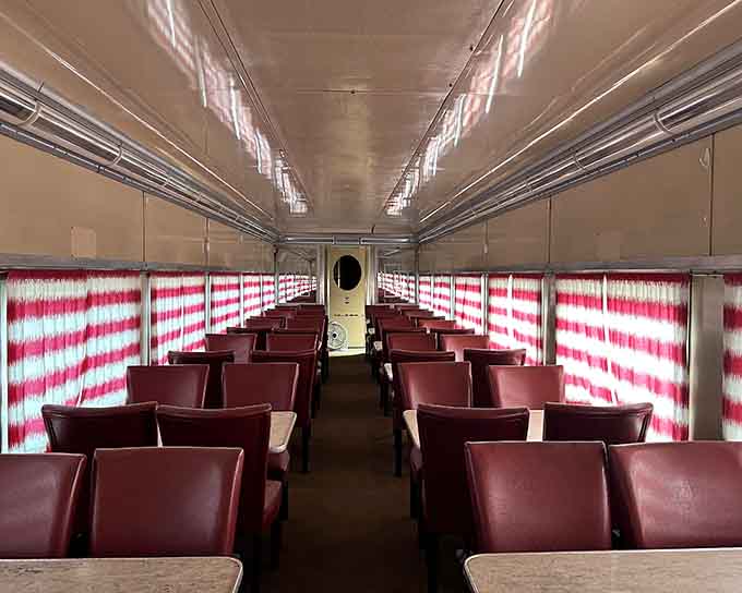 Vintage seating with candy-cane striped curtains, because train travel used to mean style and actual legroom.