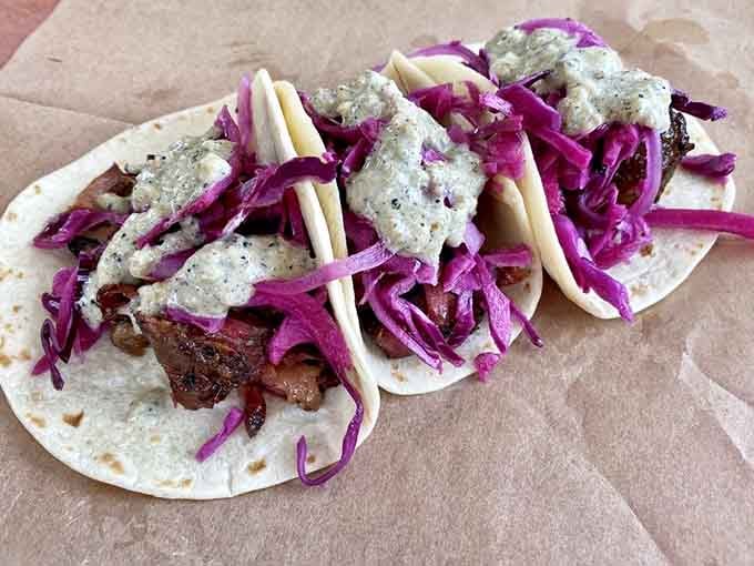 Brisket tacos topped with purple cabbage and creamy sauce prove fusion done right beats fusion done fancy.