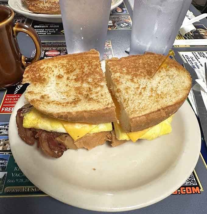 This sandwich understands that mornings require serious fuel, stacked high with eggs, meat, and melted cheese perfection.