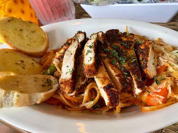 Sliced chicken crowning a bed of pasta that looks like it came straight from someone's island vacation dreams.