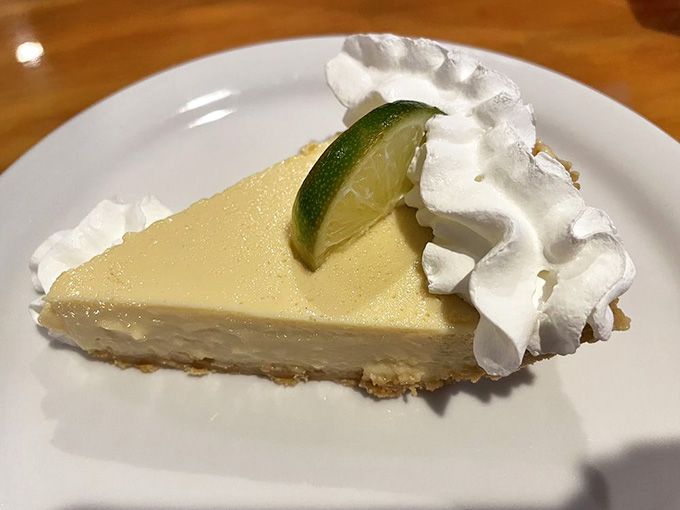 Key lime pie with a cloud of whipped cream, tart enough to make your face scrunch up in the best possible way.