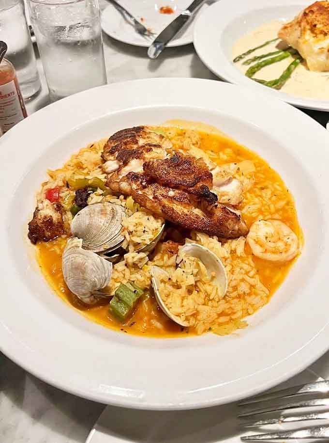 Pan-saut&eacute;ed blackened red snapper surrounded by clams and rice that looks better than most vacation photos you've posted.