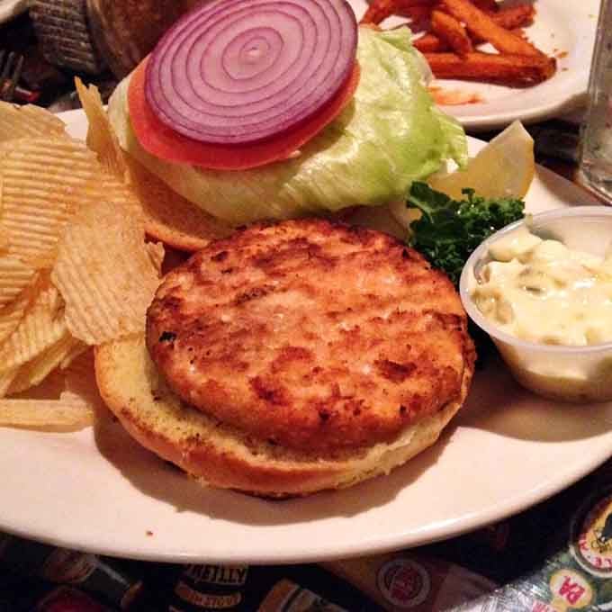 A crab cake sandwich that comes with lettuce, tomato, onion, and the kind of tartar sauce that makes everything better.