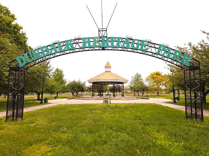 Heritage Park's welcoming arch frames green space where families gather without country club membership fees required.