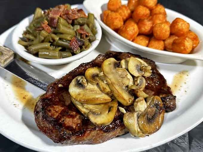 A ribeye topped with mushrooms and flanked by tater tots is basically the Midwestern dream team assembled.