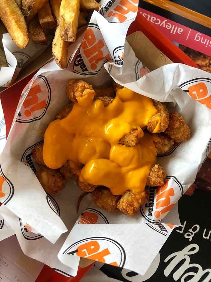 Cheese tots drowning in molten cheddar represent everything right with American comfort food in one glorious basket.