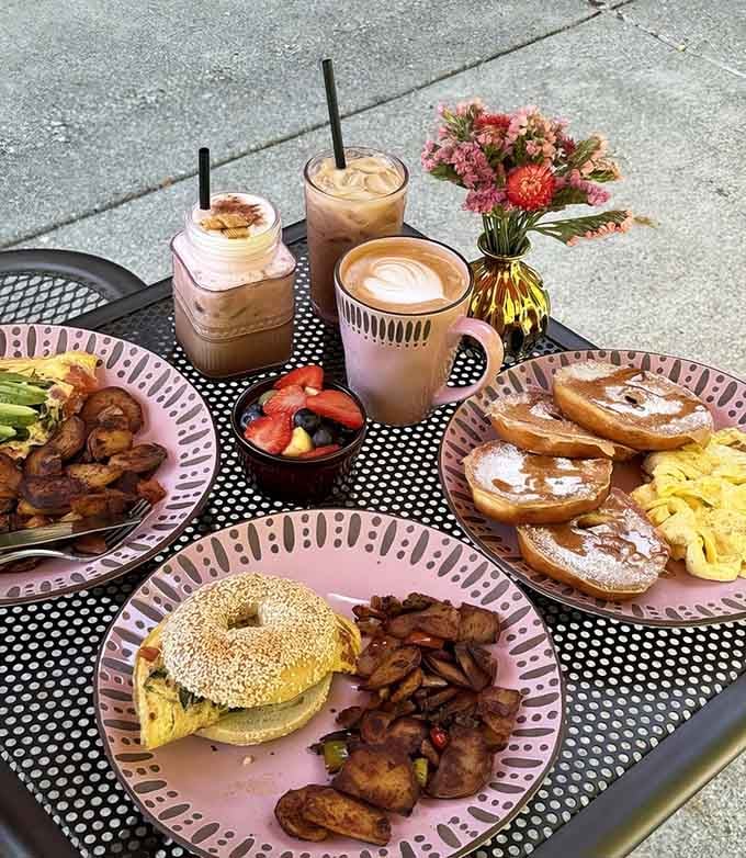 Pink plates loaded with bagel sandwiches, bacon, and enough coffee to fuel a small army through the entire weekend.