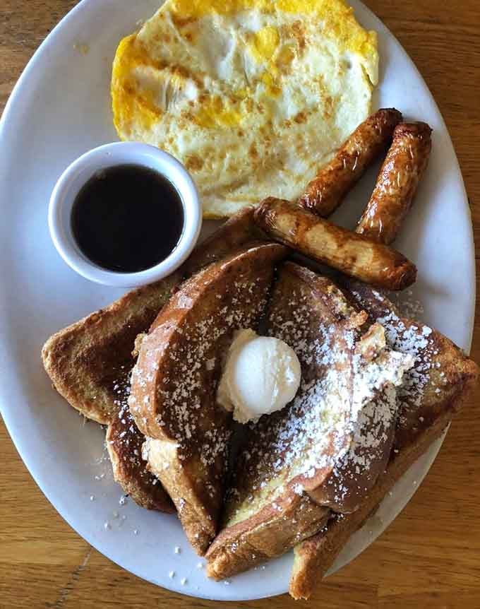 French toast that understands the assignment, accompanied by sausage links and eggs that complete this morning masterpiece flawlessly.
